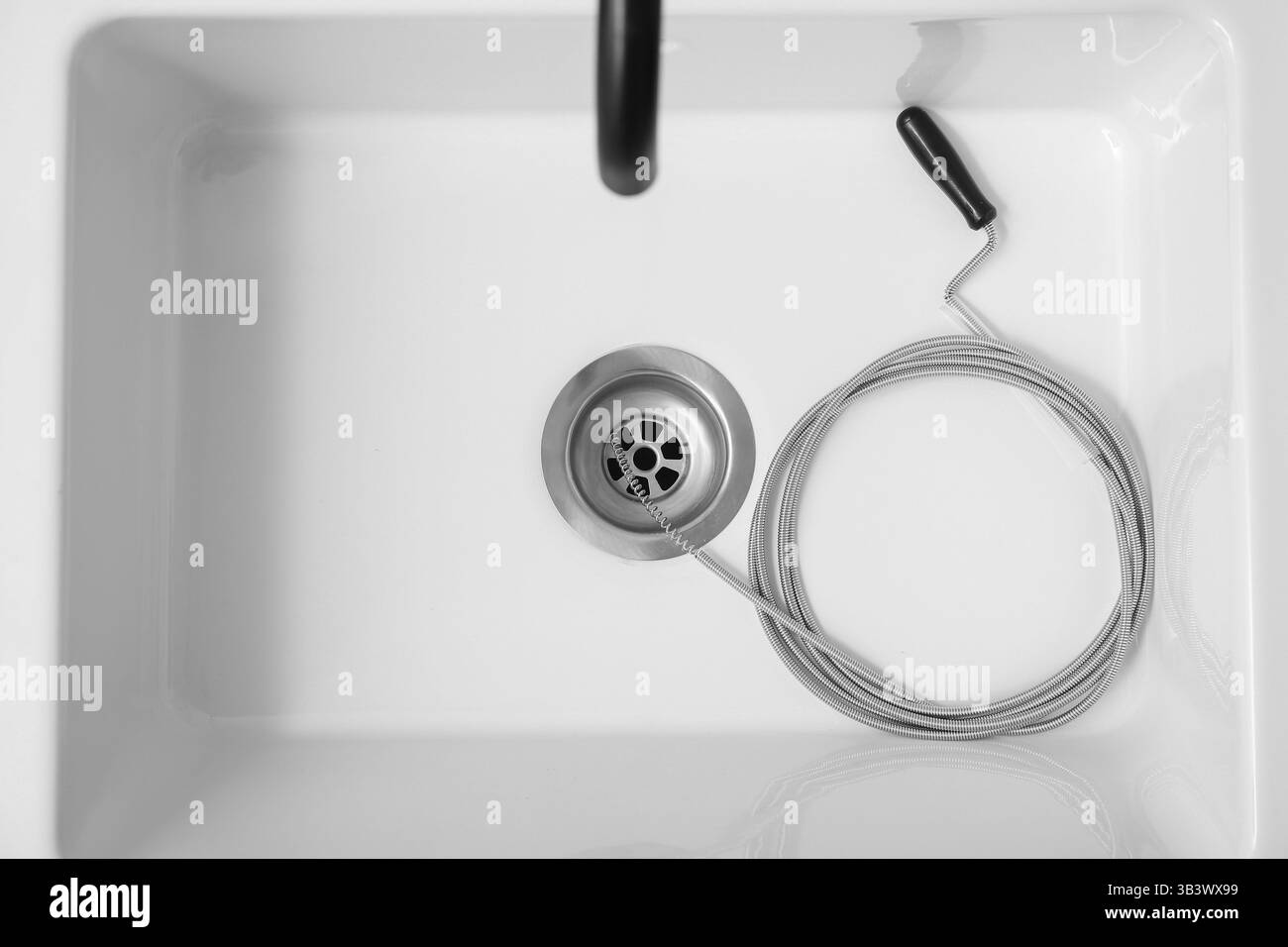 Sink with clogged drain and plumber's snake, top view Stock Photo - Alamy