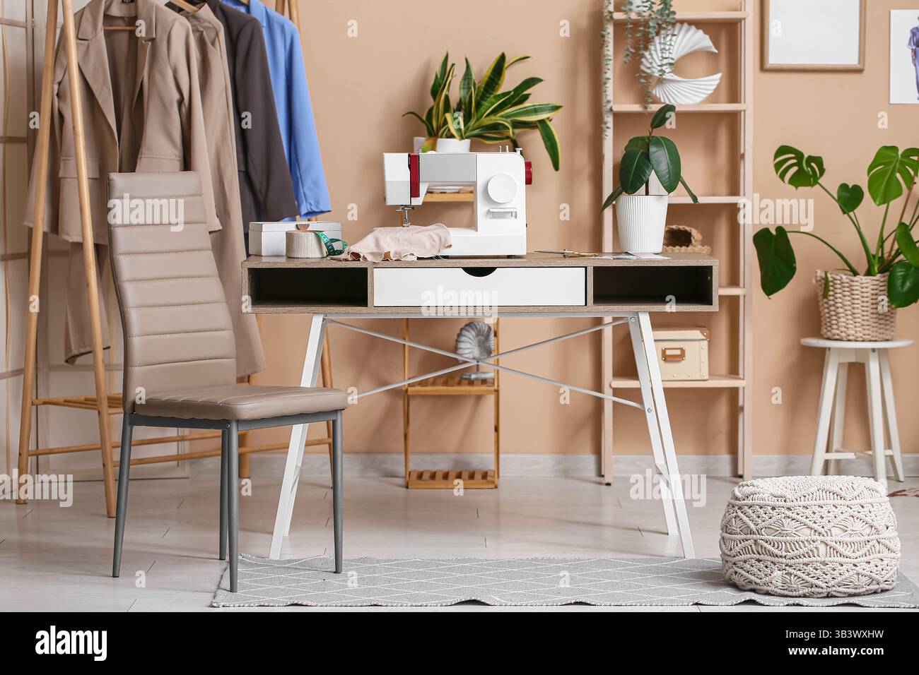 Interior of atelier with tailor's workplace, clothes rack and shelf ...