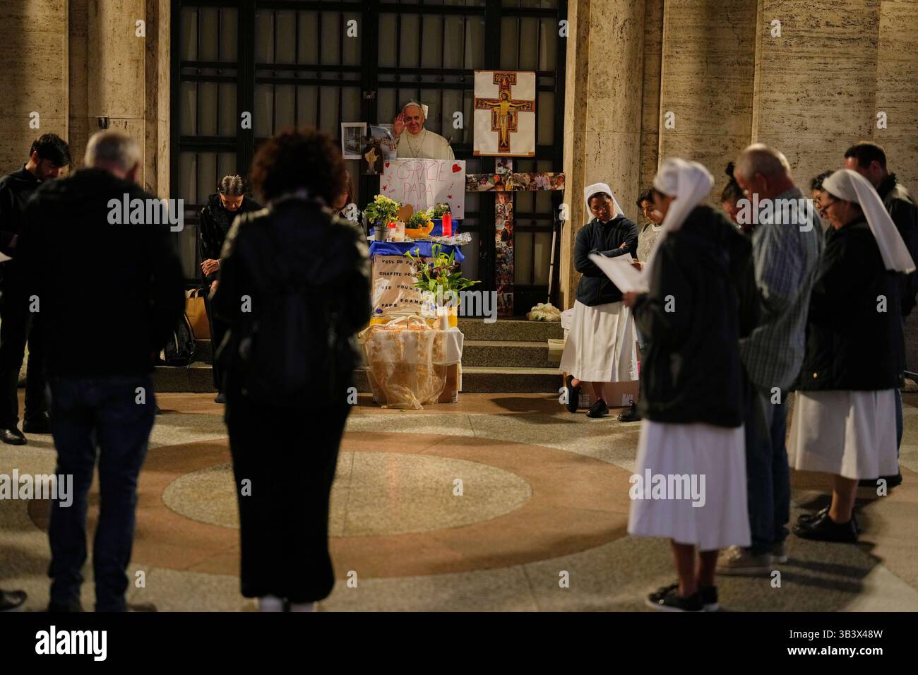 Faithfuls gather next to an altar with the photograph of late Pope ...