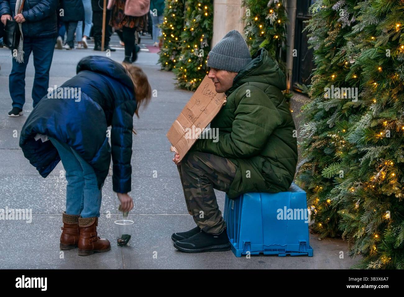 A girl giving alms to a man on the Fifth Avenue, charity, helping the ...