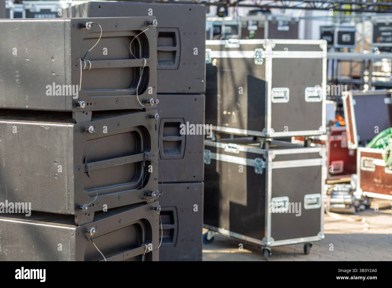 Stacks of sound equipment and lighting gear are arranged at an outdoor ...