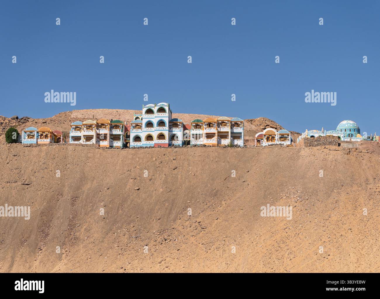 Colorful building of Nubian holiday resort on top of sandy hill in ...