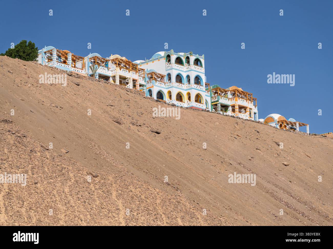 Colorful building of Nubian holiday resort on top of sandy hill in ...