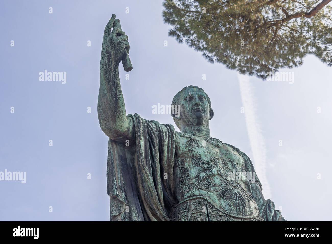 A detailed bronze statue of a Roman emperor holds a scroll high ...