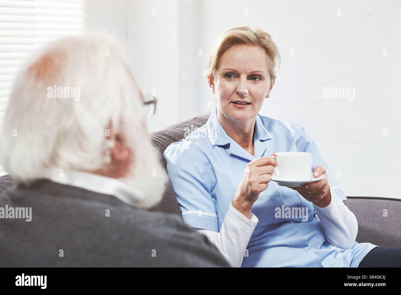 Caring caregiver, caretaker and healthcare professional sitting with ...