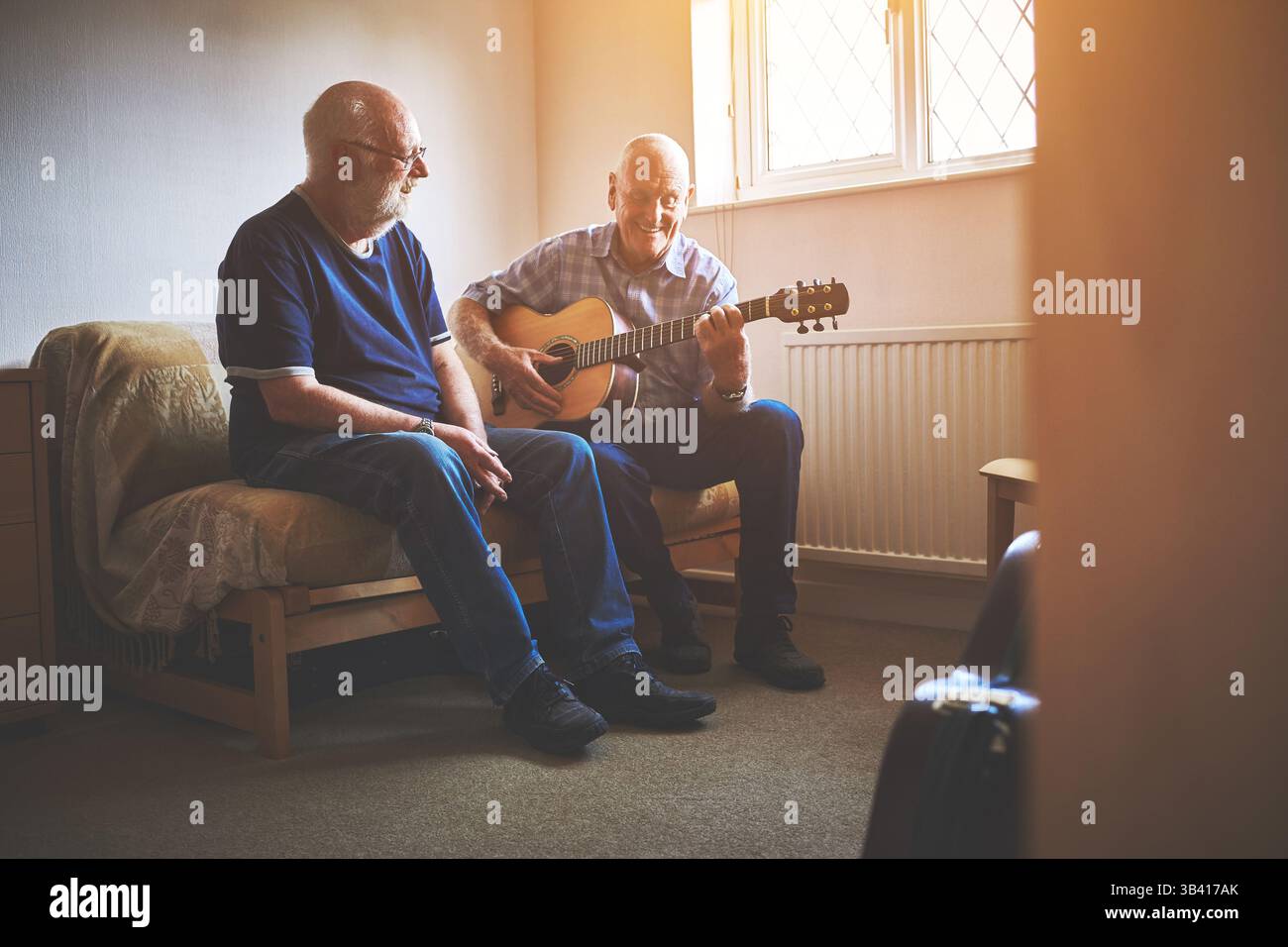 Senior men having fun with a guitar, bonding while playing music ...
