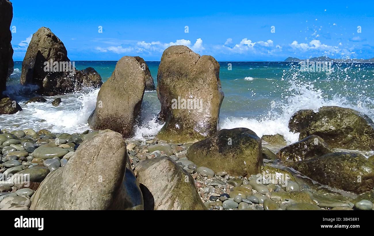 Rock formations on a tropical beach washed by the surf on a sunny day ...