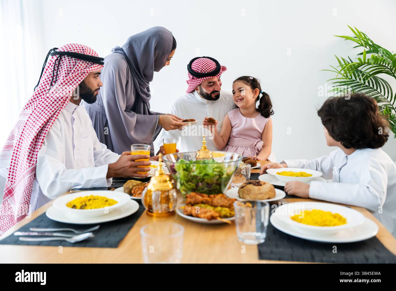 Happy arab family wearing saudi arabia clothing spending time together ...