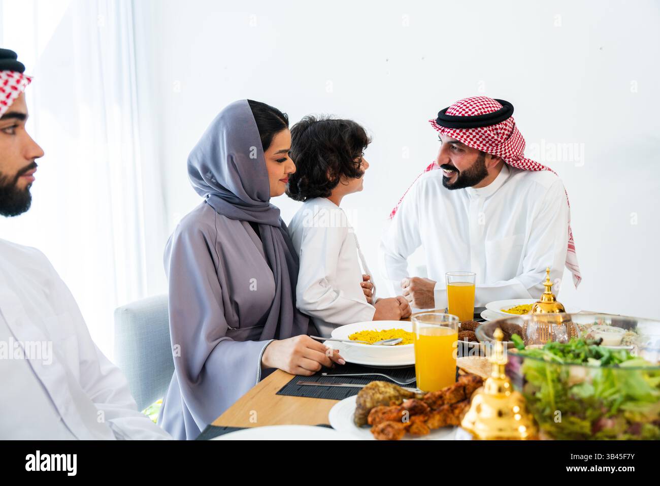 Happy arab family wearing saudi arabia clothing spending time together ...