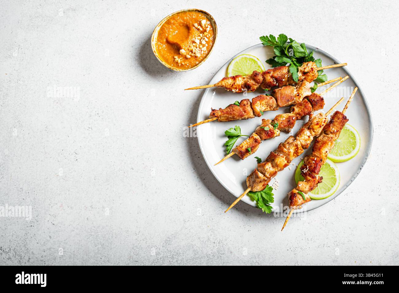 Malaysian chicken satay skewers with peanut sauce on white background ...