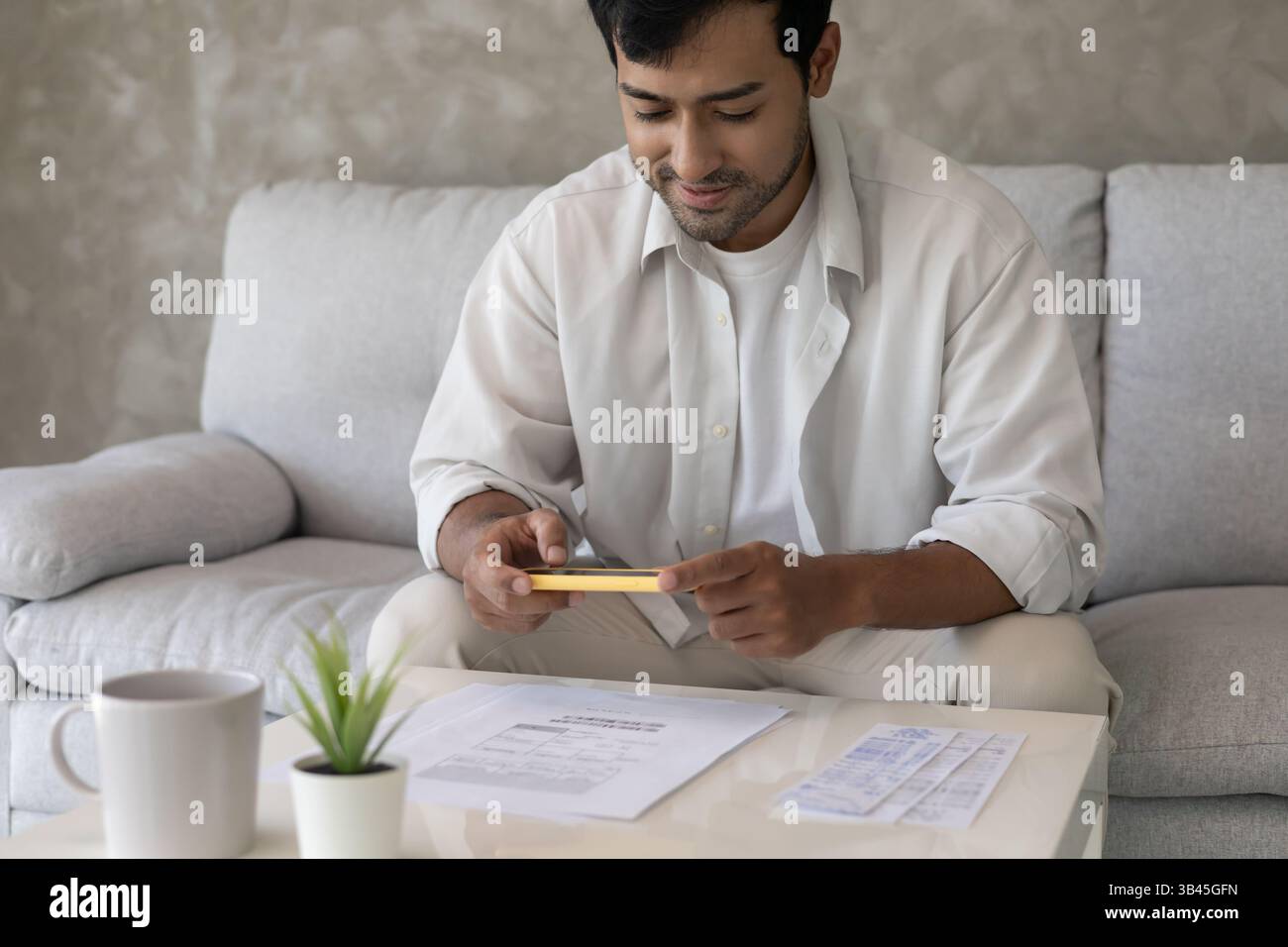 man use phone to scan barcode or QR codes to pay credit card bill after ...