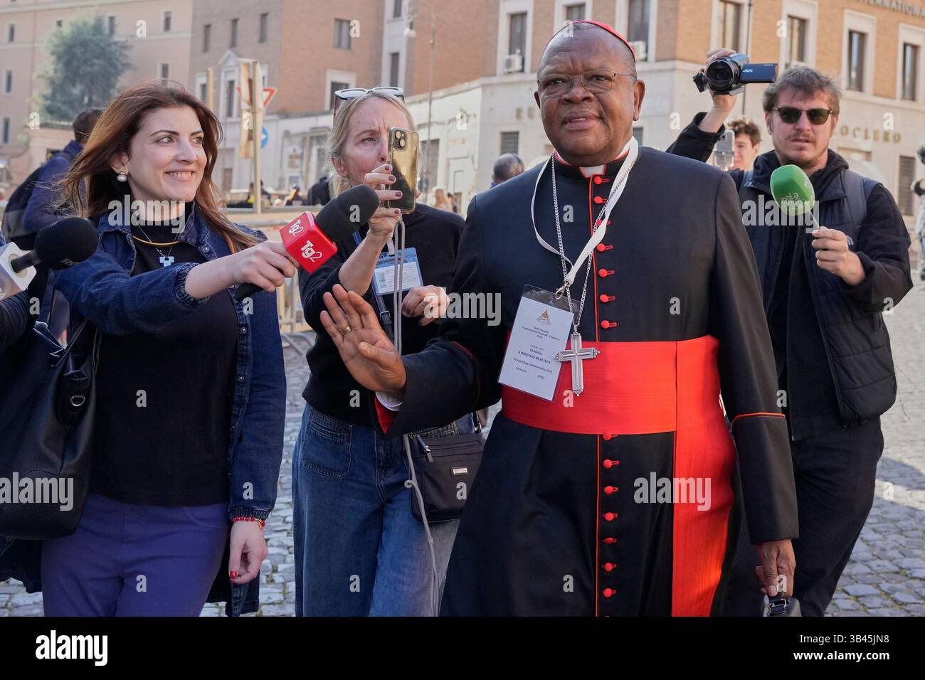 Cardinal Fridolin Ambongo Besungu is approached by reporters as he ...