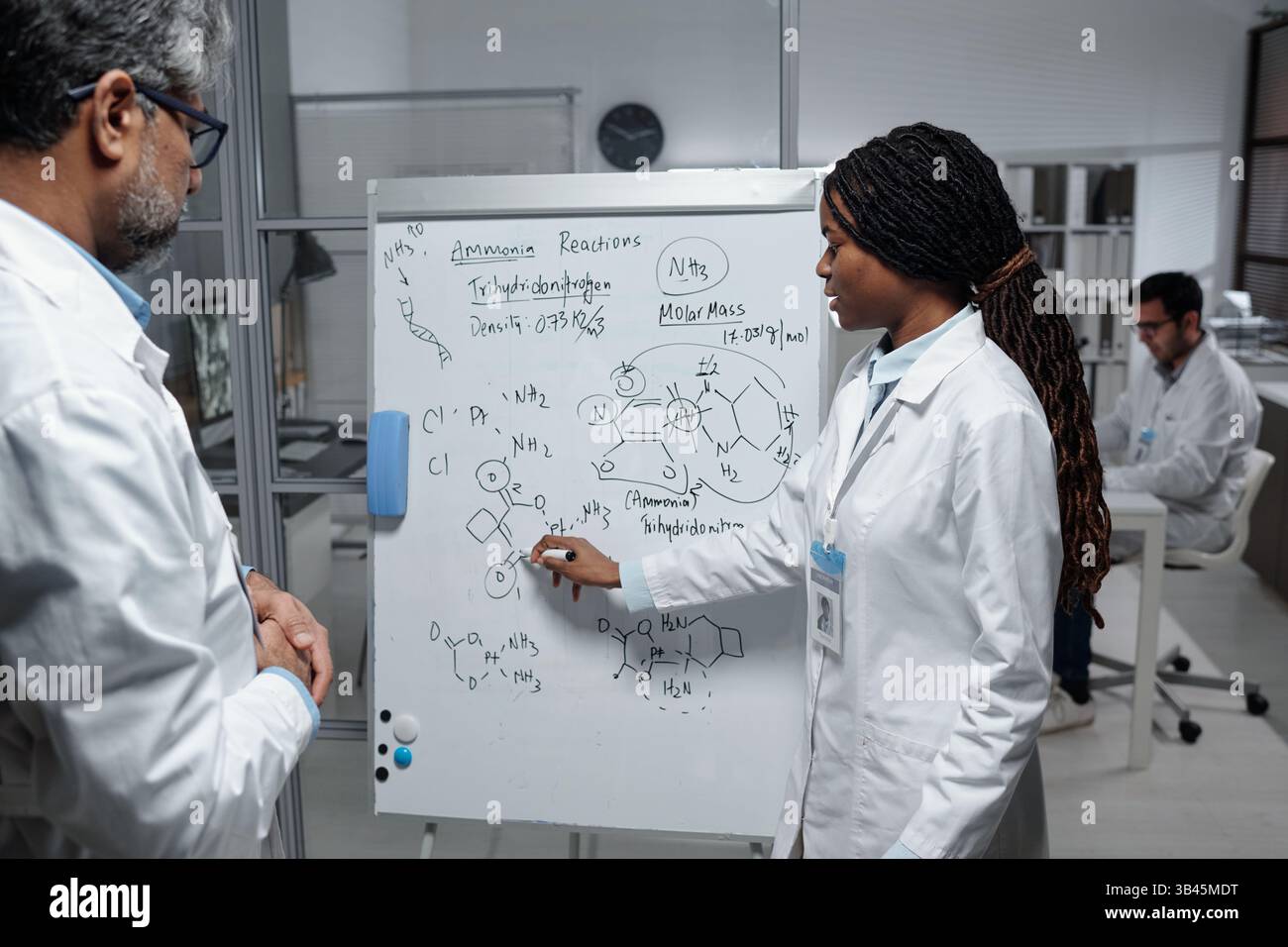 Team of scientists conducting research in laboratory, discussing ...