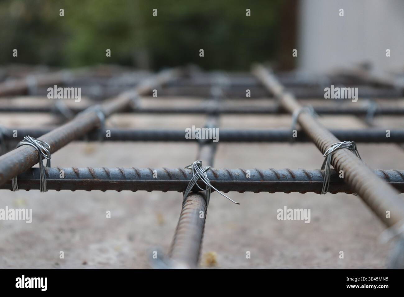 Close up shot showing a rebar grid structure made of ribbed steel bars tied together with wire ...