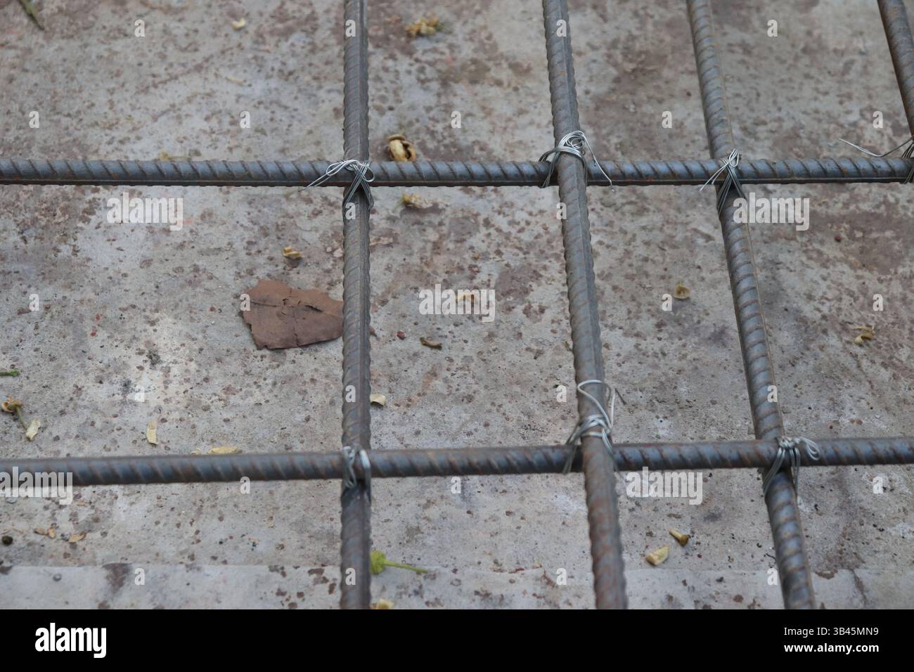 Steel reinforcing bars tied into a grid, secured with wire. Metal grid ...