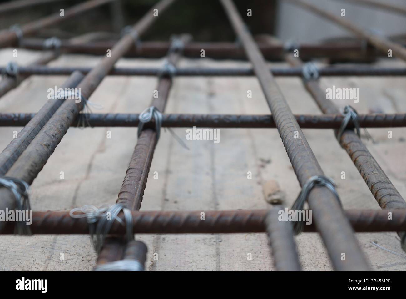 Close-up shot capturing steel rebar reinforced with wire at a construction site. Grid pattern of ...