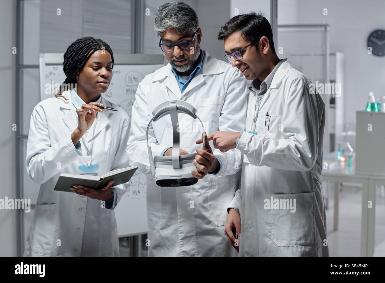 Group of diverse scientists discussing new medical device in laboratory ...