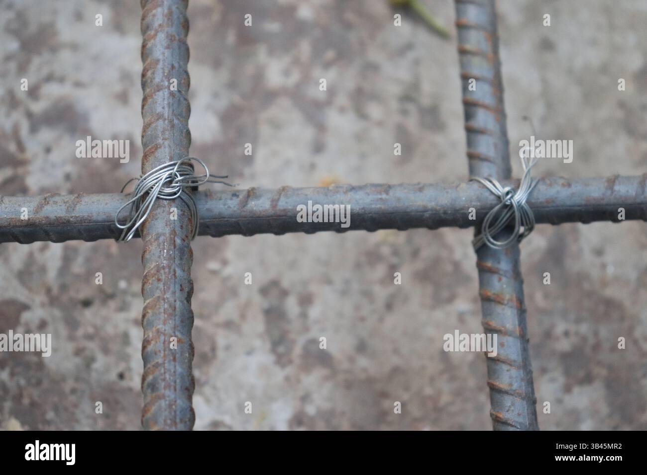 Metal bars are crossed and secured with wire to form a grid. Rusted ...