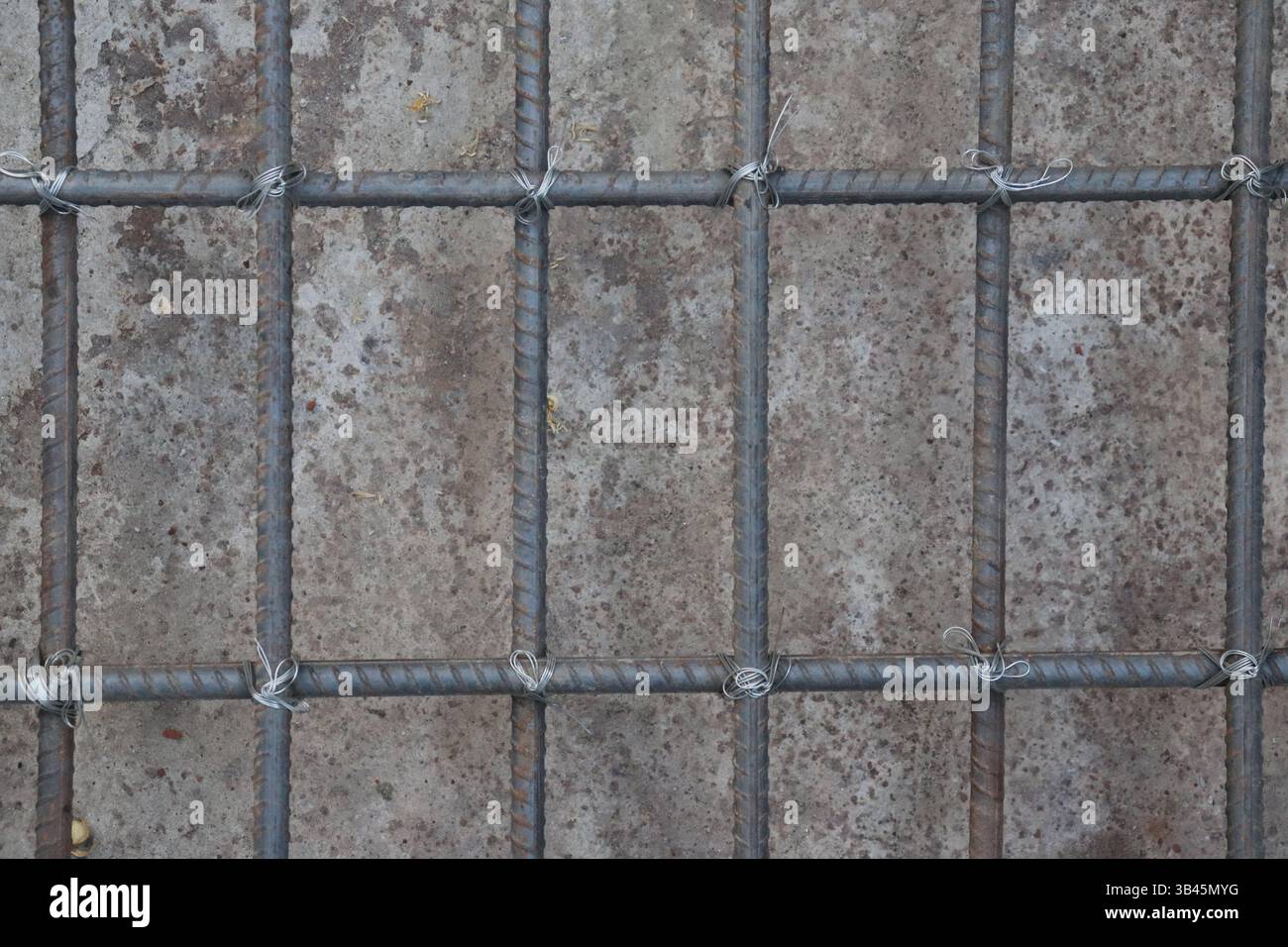 View shows steel rebar gridwork bound with wire, set on concrete ...