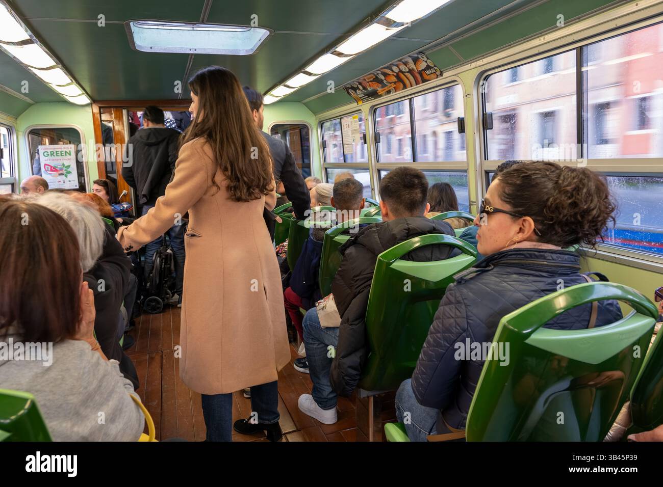 Vaporetto water bus interior with passengers, public transport in ...