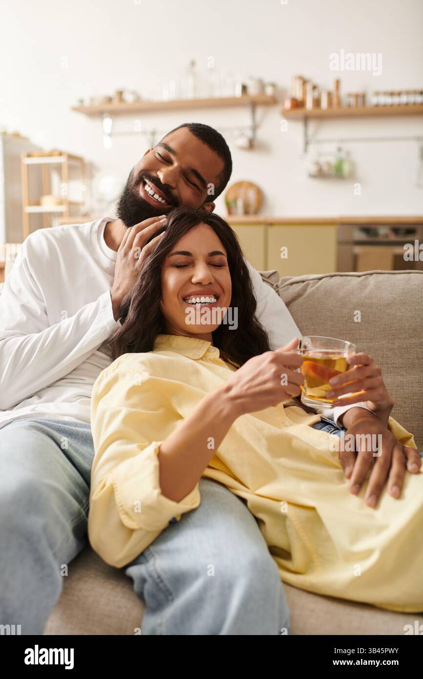 A happy African American couple sips tea together in their cozy living ...