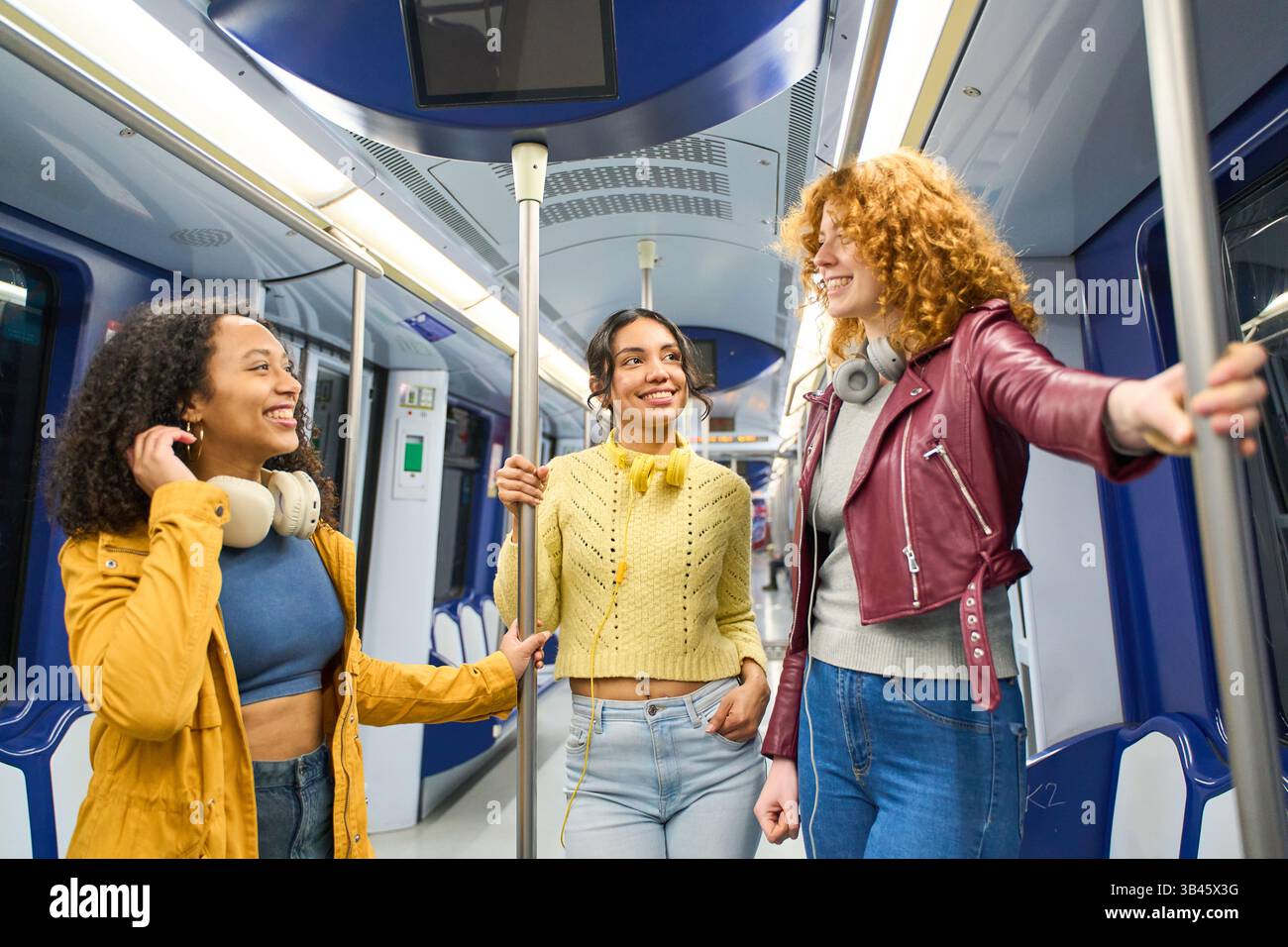 Three young female students are enjoying their commute on a modern ...