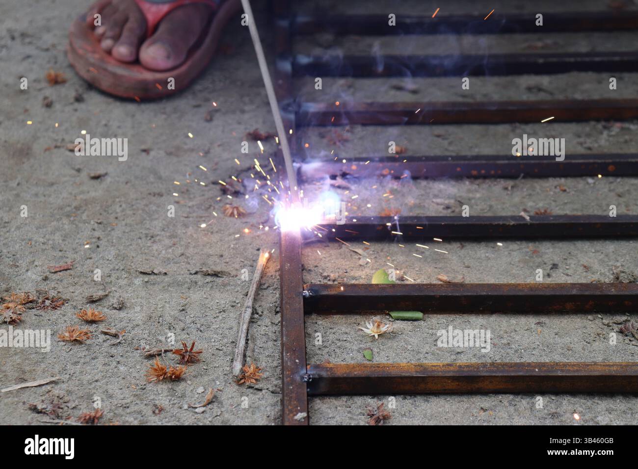 Close-up capturing welding activity. Welder sparks illuminate joining ...