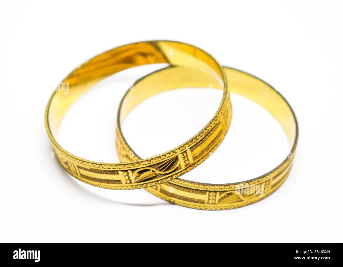 Isolated ornate gold bangles on a white background. These traditional ...