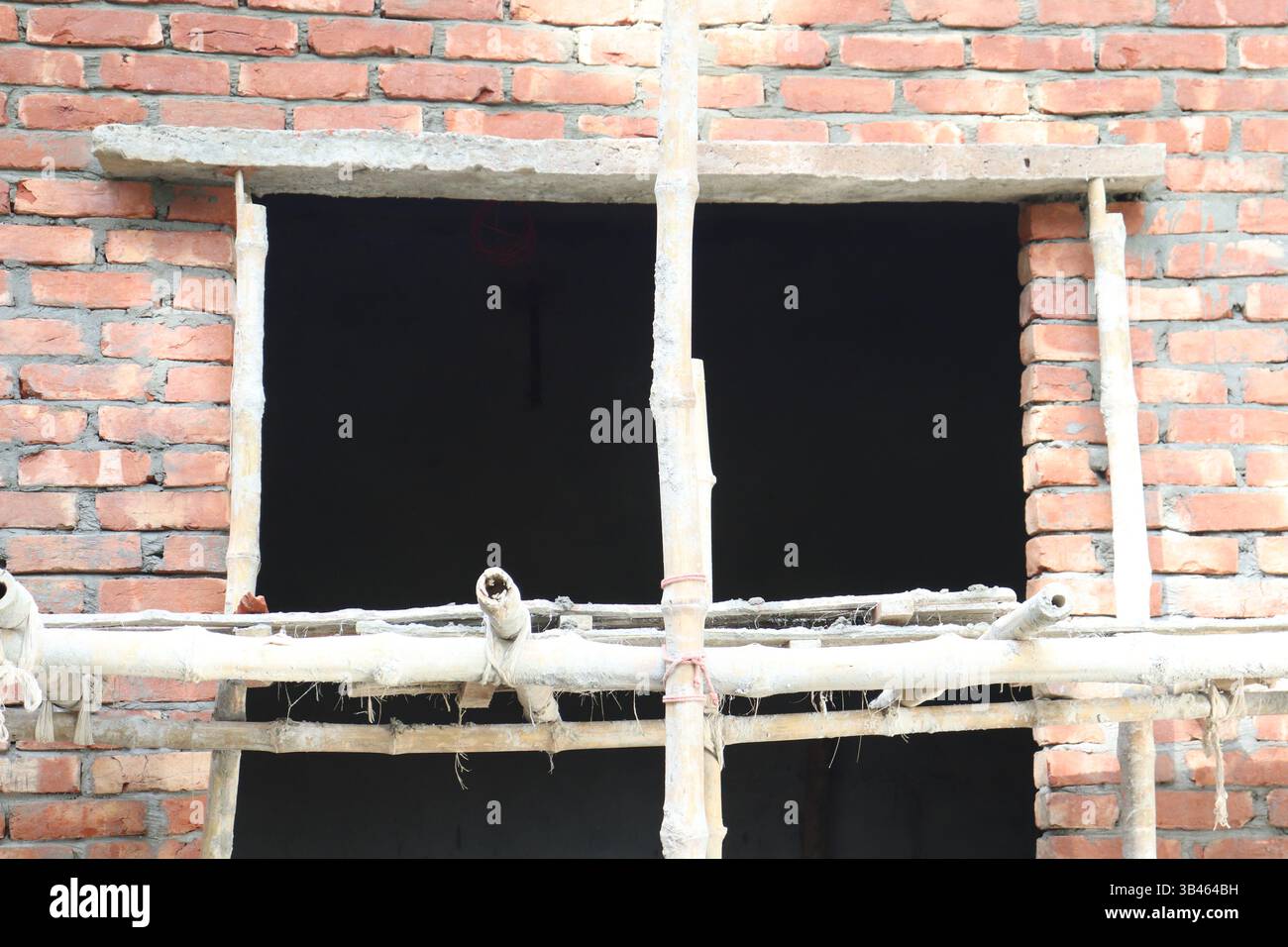 Construction site featuring a brick wall, a window opening reinforced ...