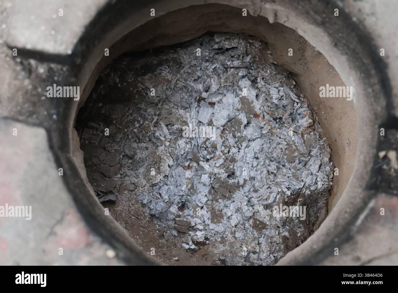 Top-down shot showing a filled circular brick oven with remnants of ...