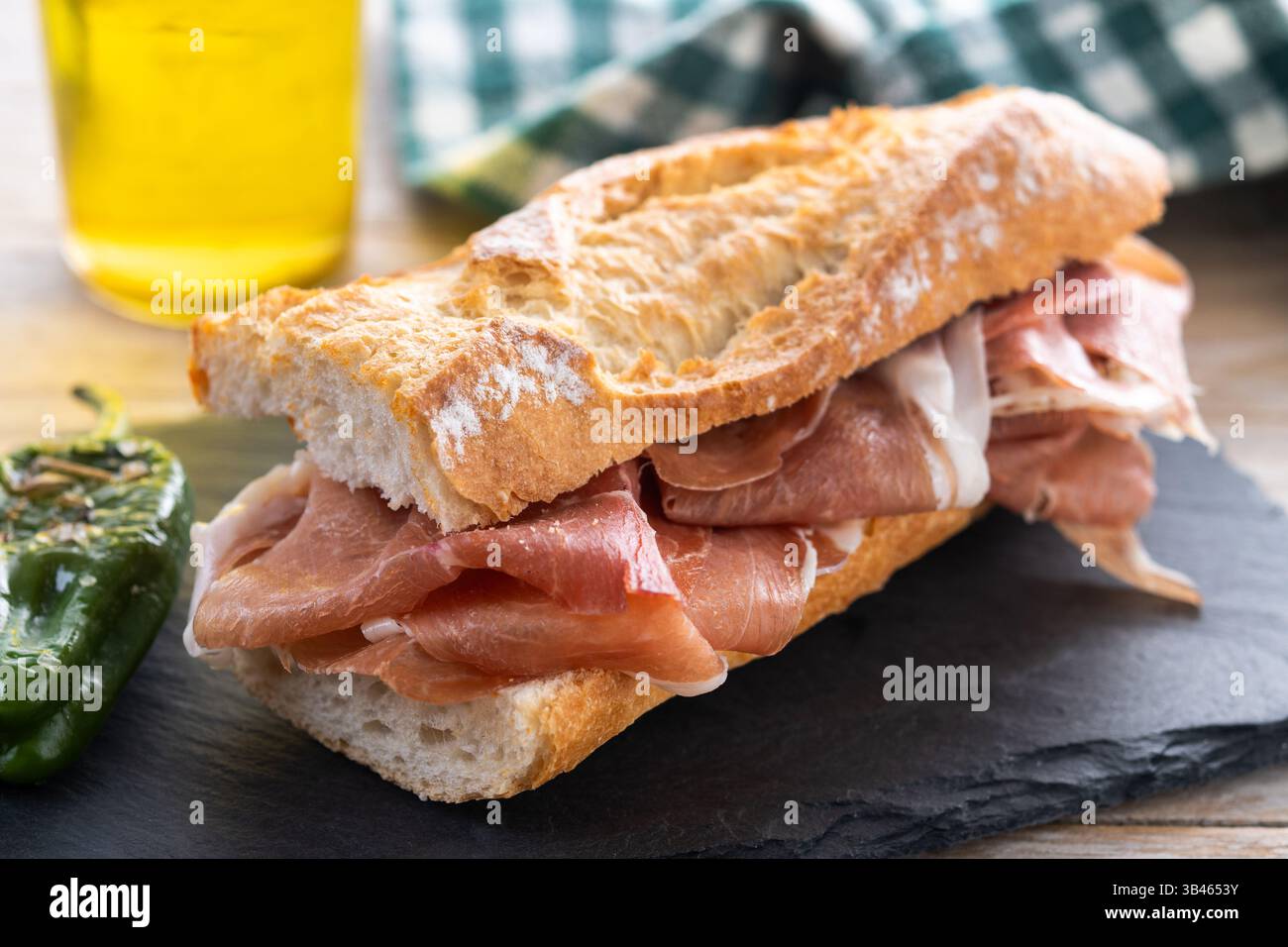 Spanish serrano ham sandwich on wooden table. Spanish bocadillo de ...