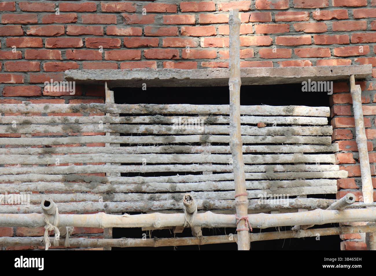 An image features a brick wall, bamboo scaffolding, and concrete lintel ...