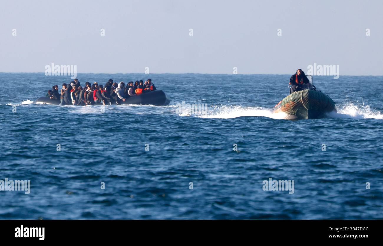 A packed migrant dinghy is seen in French territorial waters of The ...
