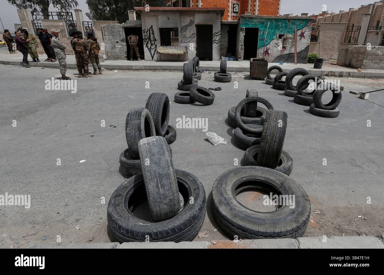 Syrian government security forces stand guard on their checkpoint at ...