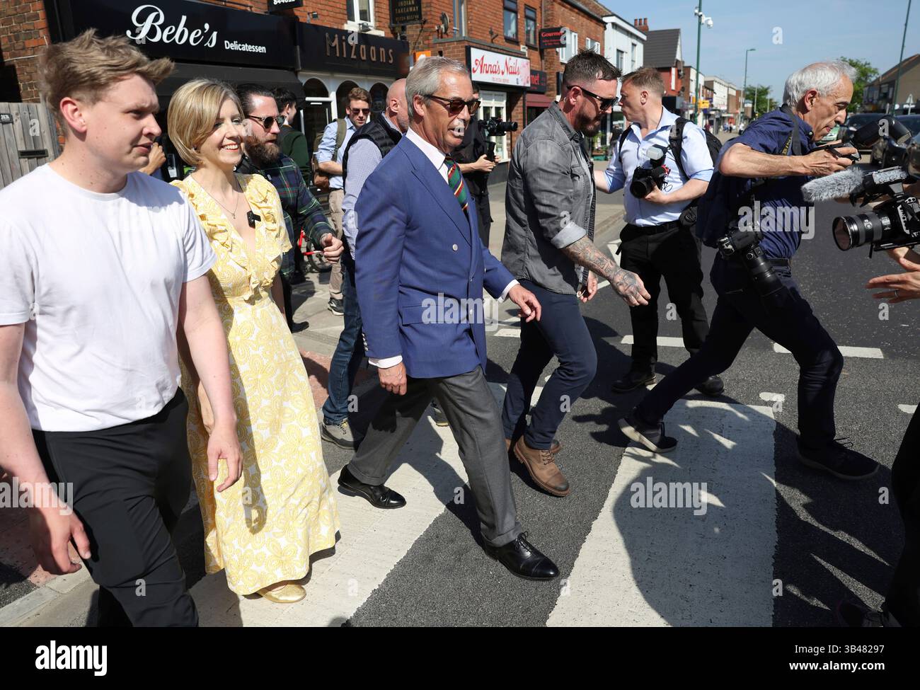 Reform UK leader Nigel Farage crosses the road with Reform UK mayoral ...