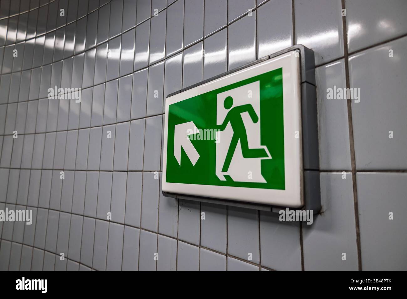 Green emergency exit sign with running man icon Stock Photo - Alamy