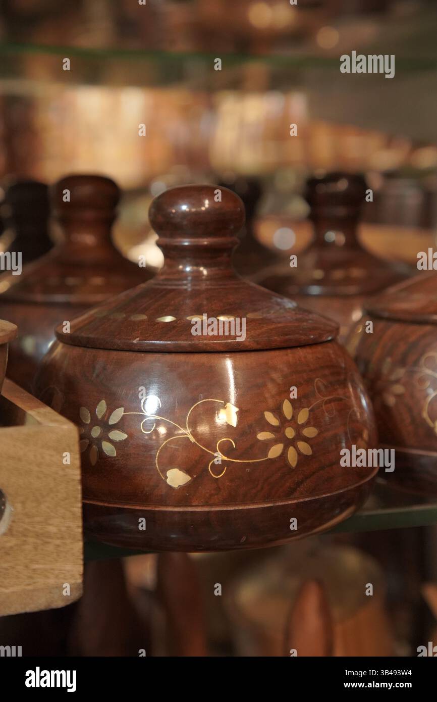 A set of intricately inlaid wooden handcrafts with lids, displayed in a ...