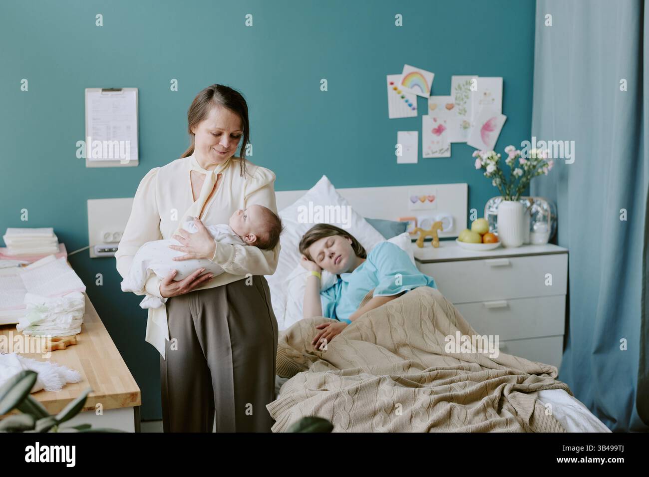 Grandmother lovingly holding baby while standing in maternity hospital ...