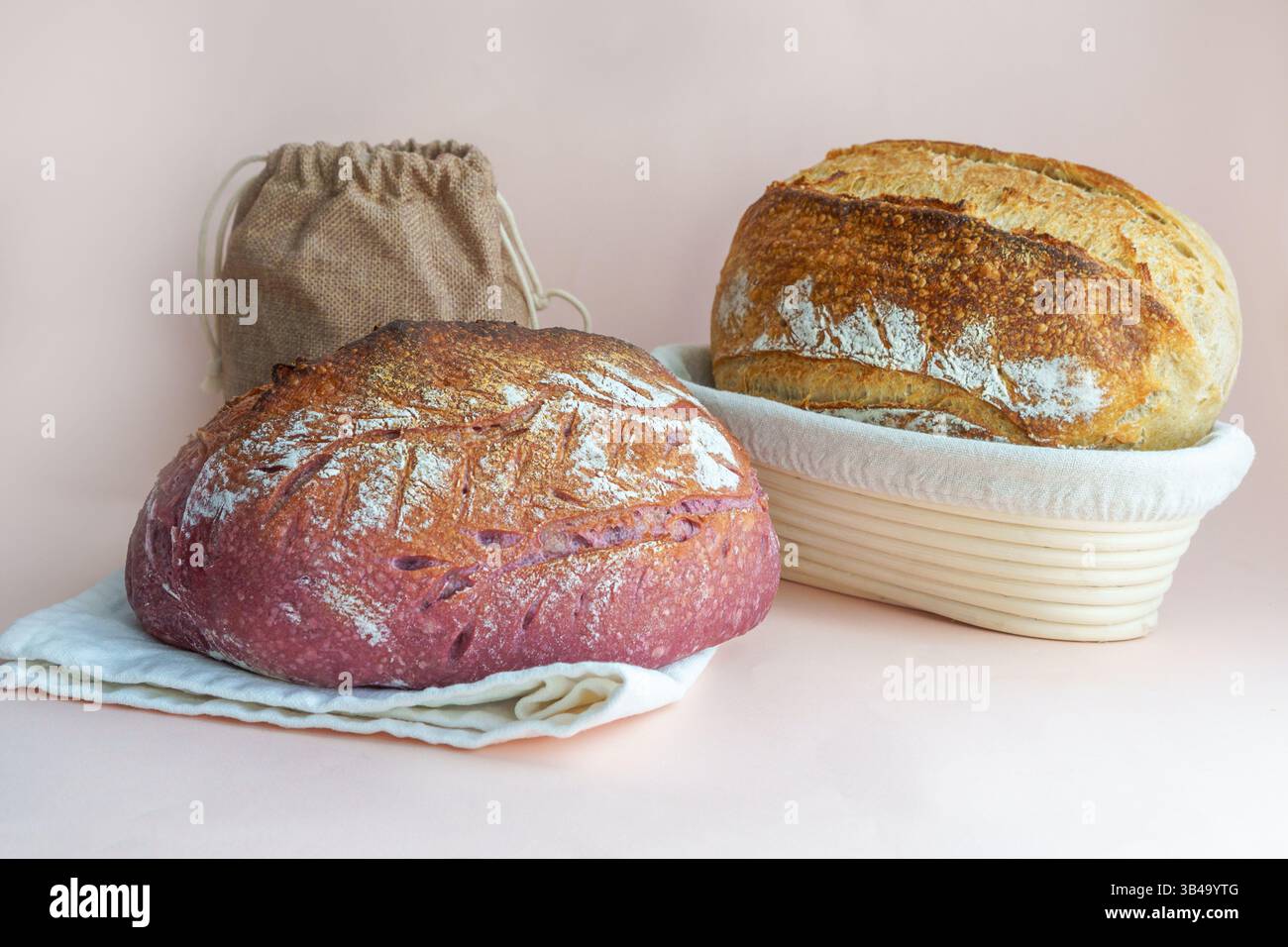 Two loafs of sourdough bread. One is a classic tartine, the other is a ...