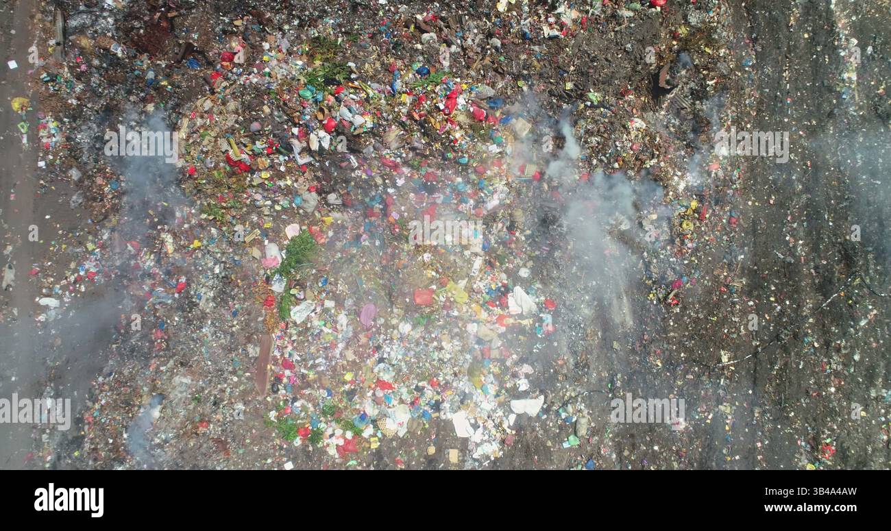 Aerial view of a smoking garbage dump with plastic waste causing air ...