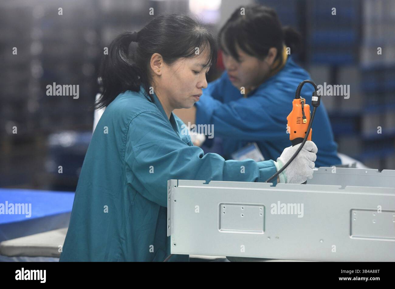 Workers assemble chasis for high-performance servers at a manufacturer ...