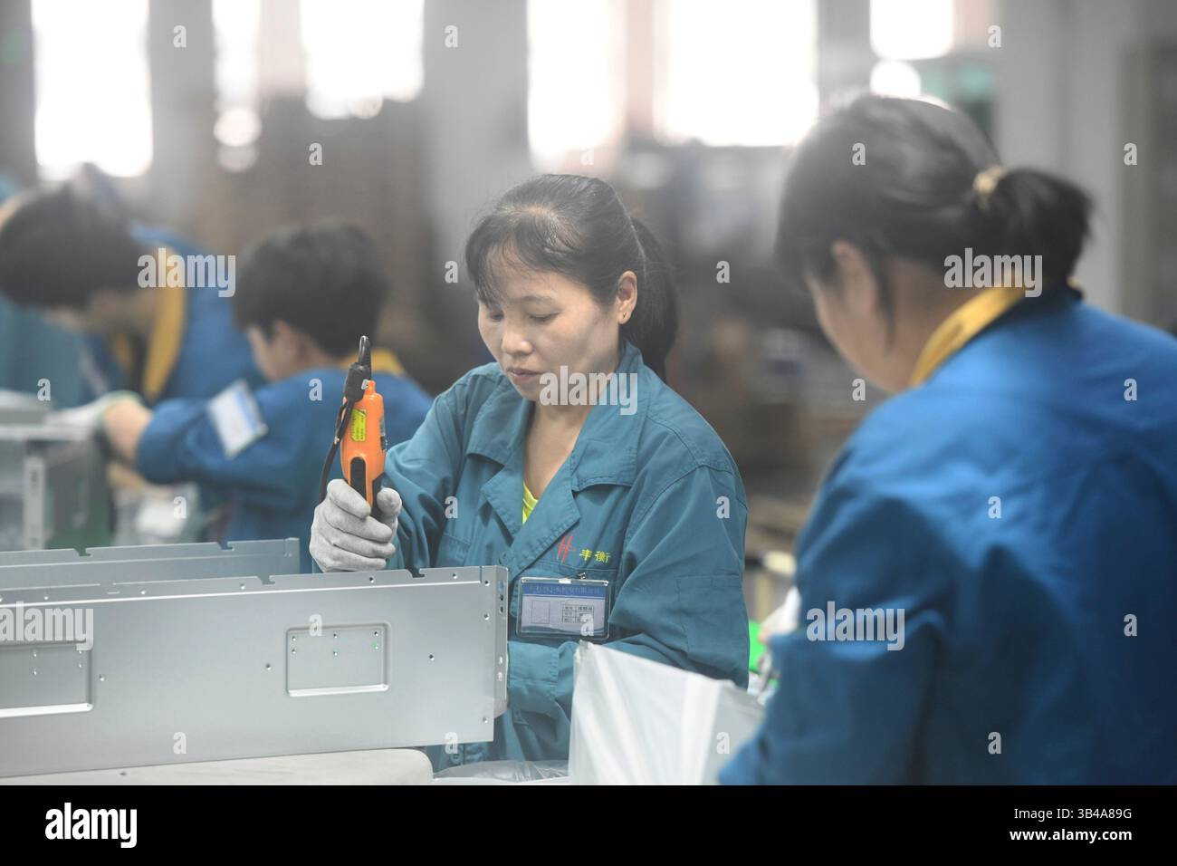 Workers assemble chasis for high-performance servers at a manufacturer ...