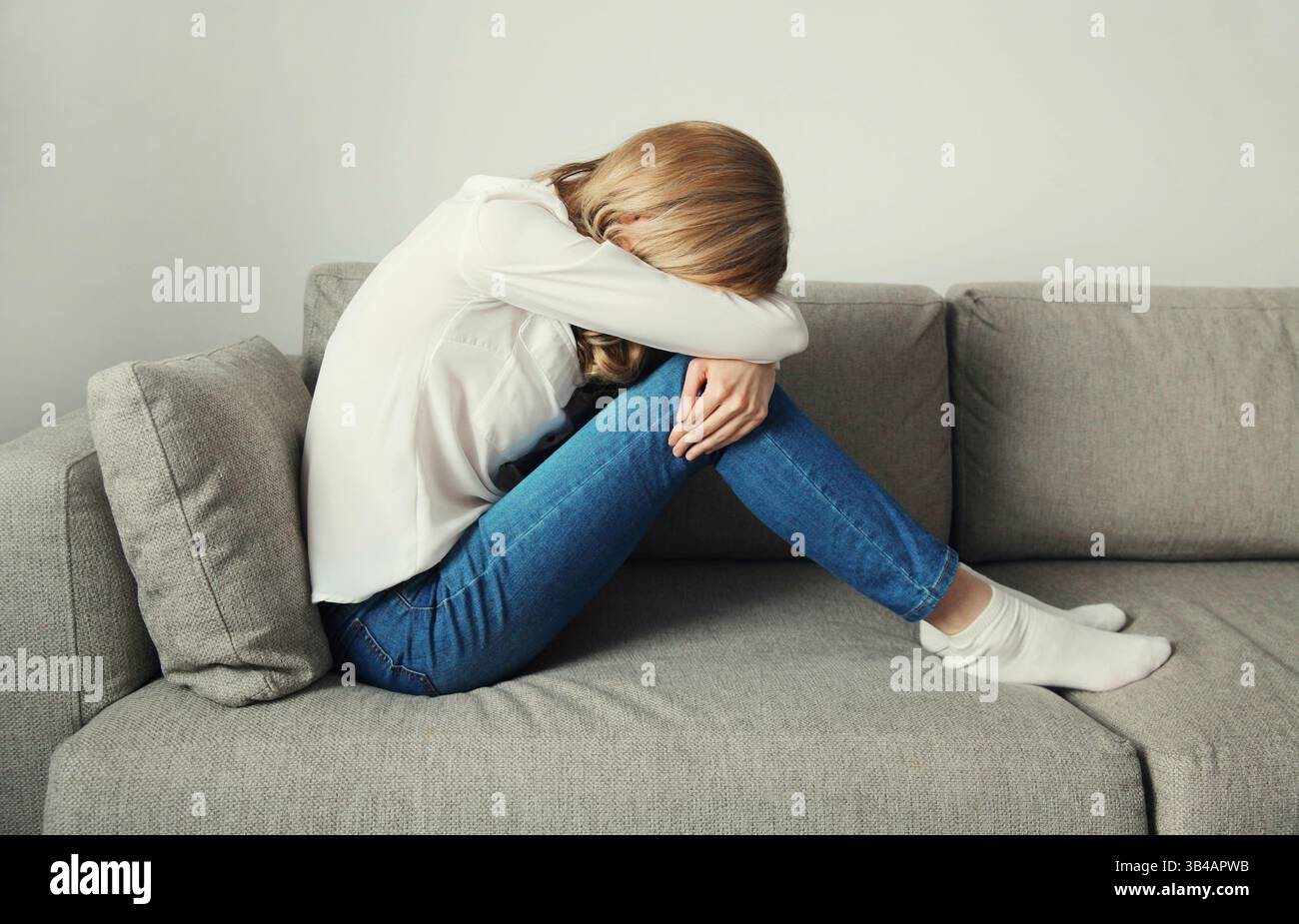 Upset sad crying young woman covering her eyes and face with her hands ...