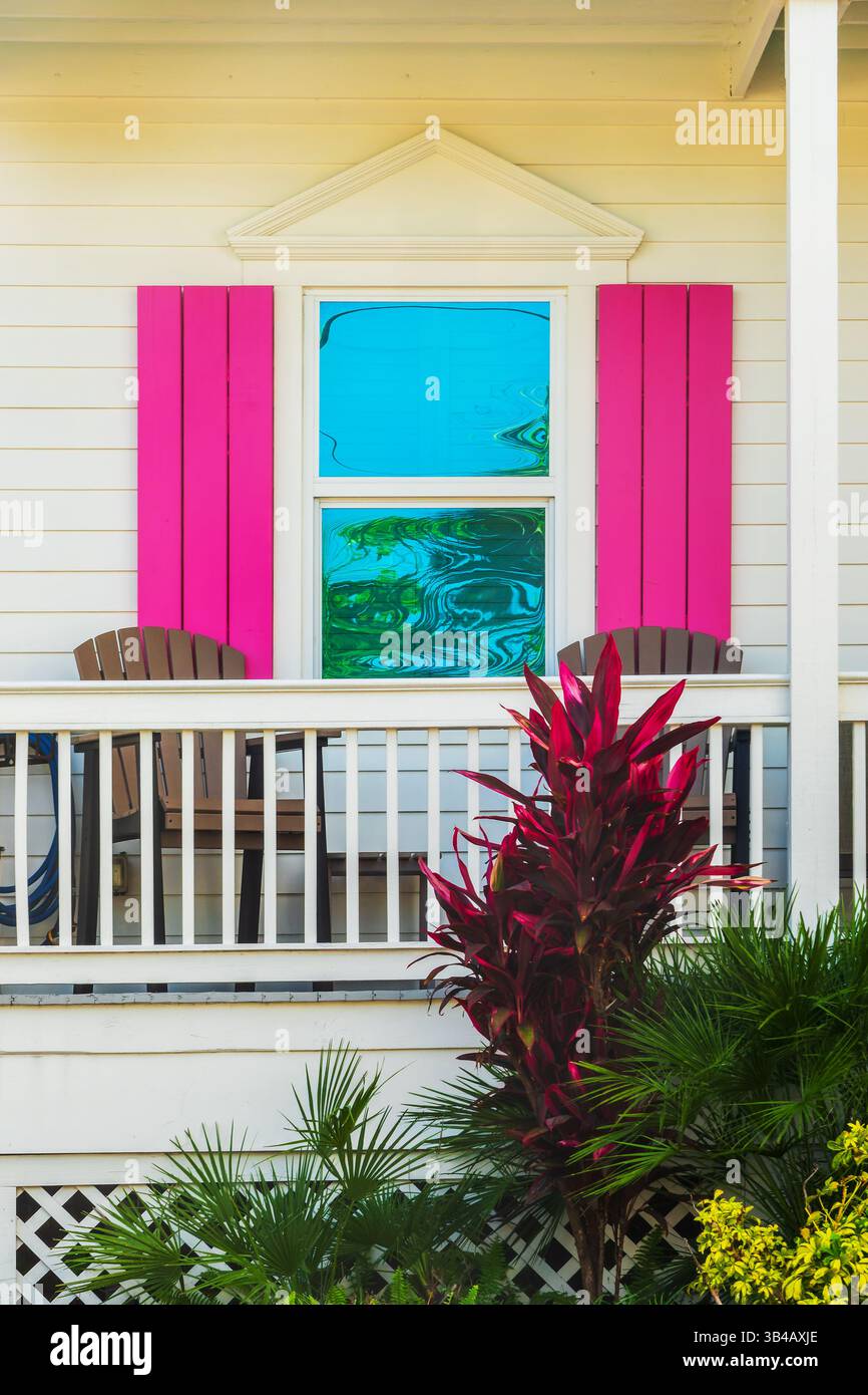 Window of a wooden house with pink shutters, colorful architecture in ...