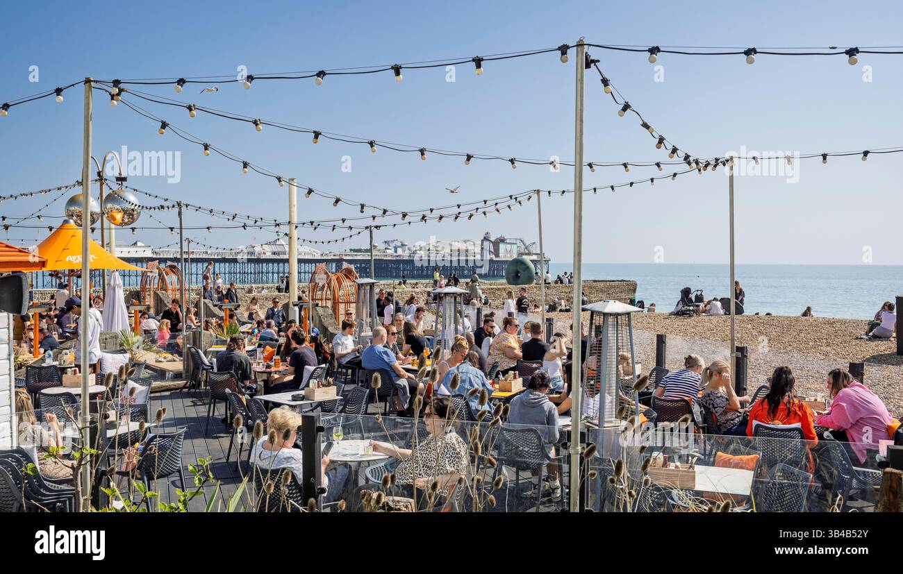 Outdoor restaurant crowded with diners on the beach in front of ...
