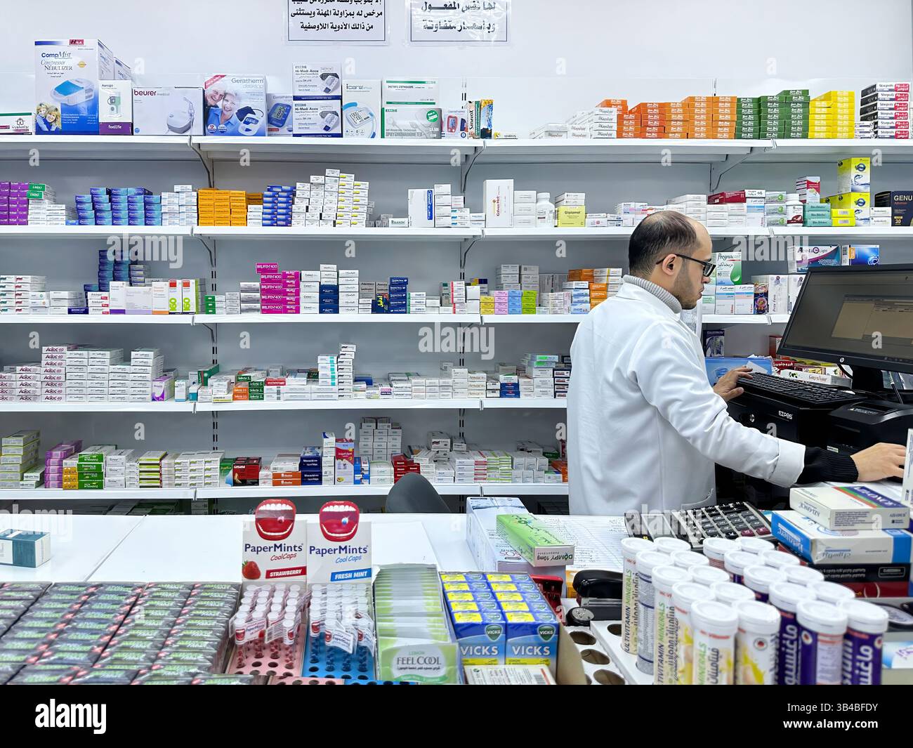 A pilgrim girl shopper in hijab and an arab pharmacist in a pharmacy ...