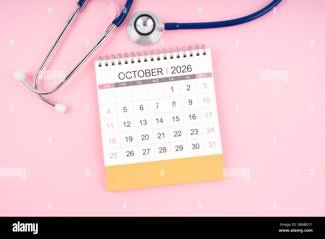 October 2026 desk calendar and Medical stethoscope on pink color ...