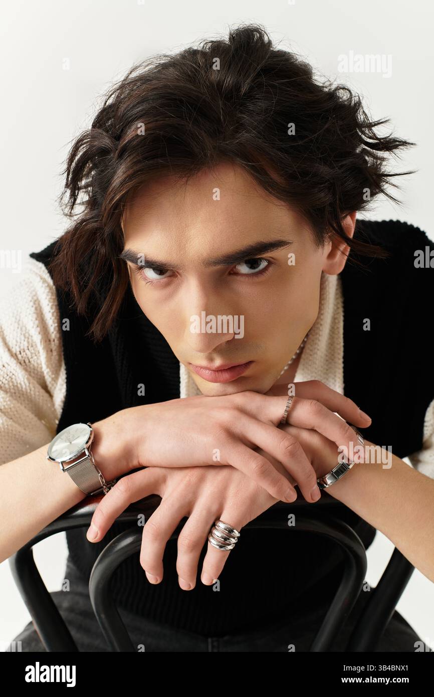 A young man with a striking look models a modern outfit while posing in ...