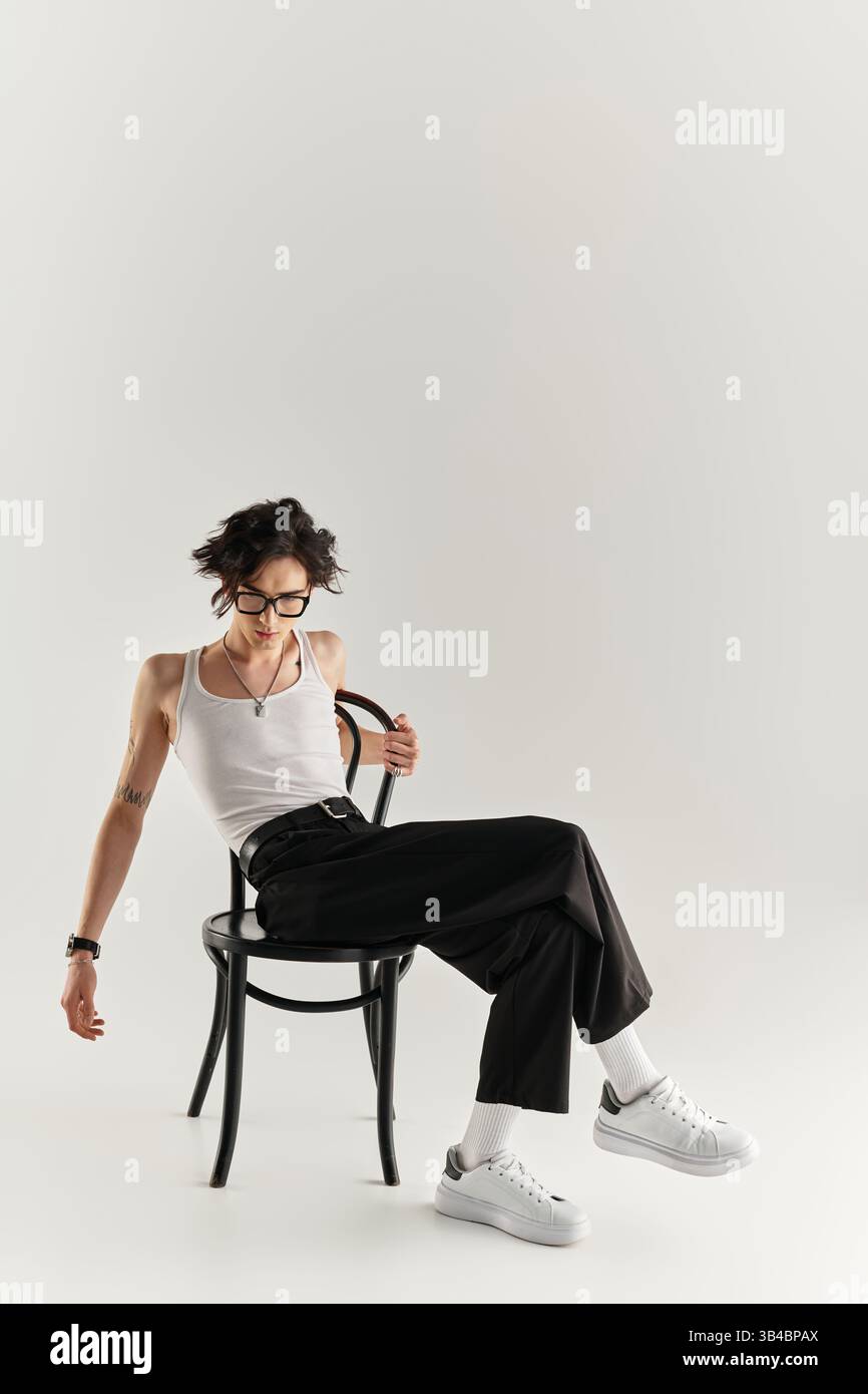 A slim young man in a white tank top showcases his trendsetting style ...