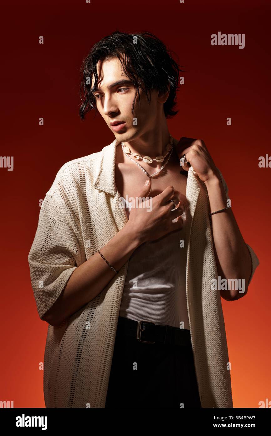 Slim young man models a chic summer outfit while posing against a bold ...